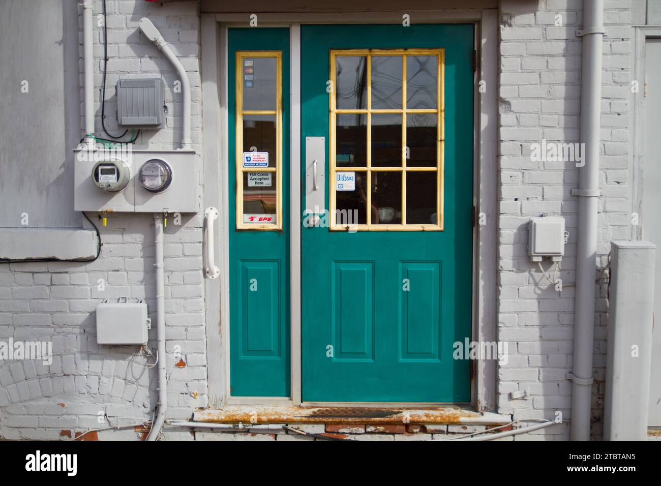 Teal Door with Yellow Framed Glass in White Brick Building Entrance ...