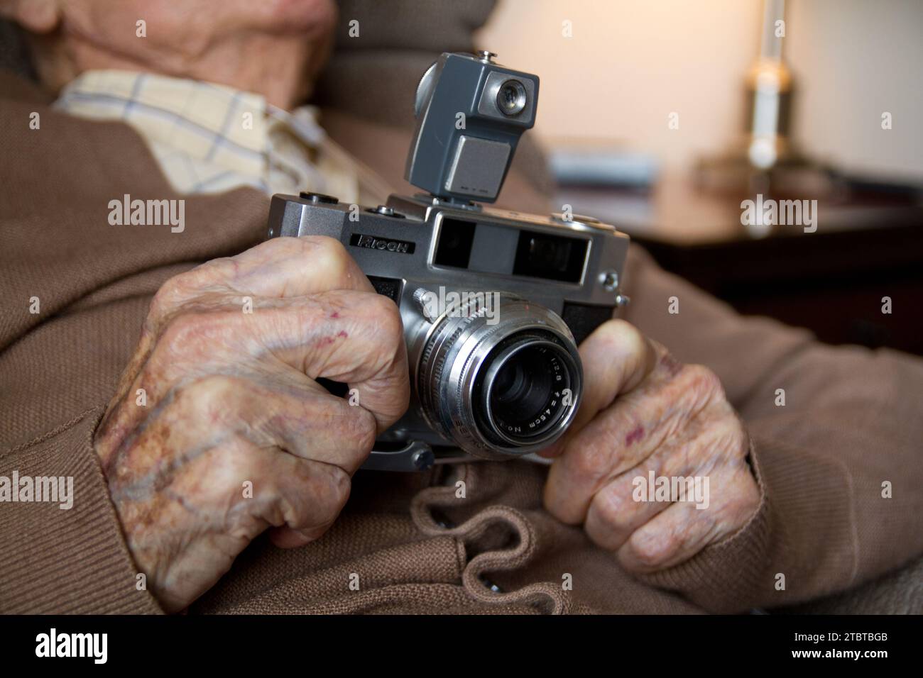 Elderly Hands Holding Vintage Camera in Soft Light Stock Photo - Alamy