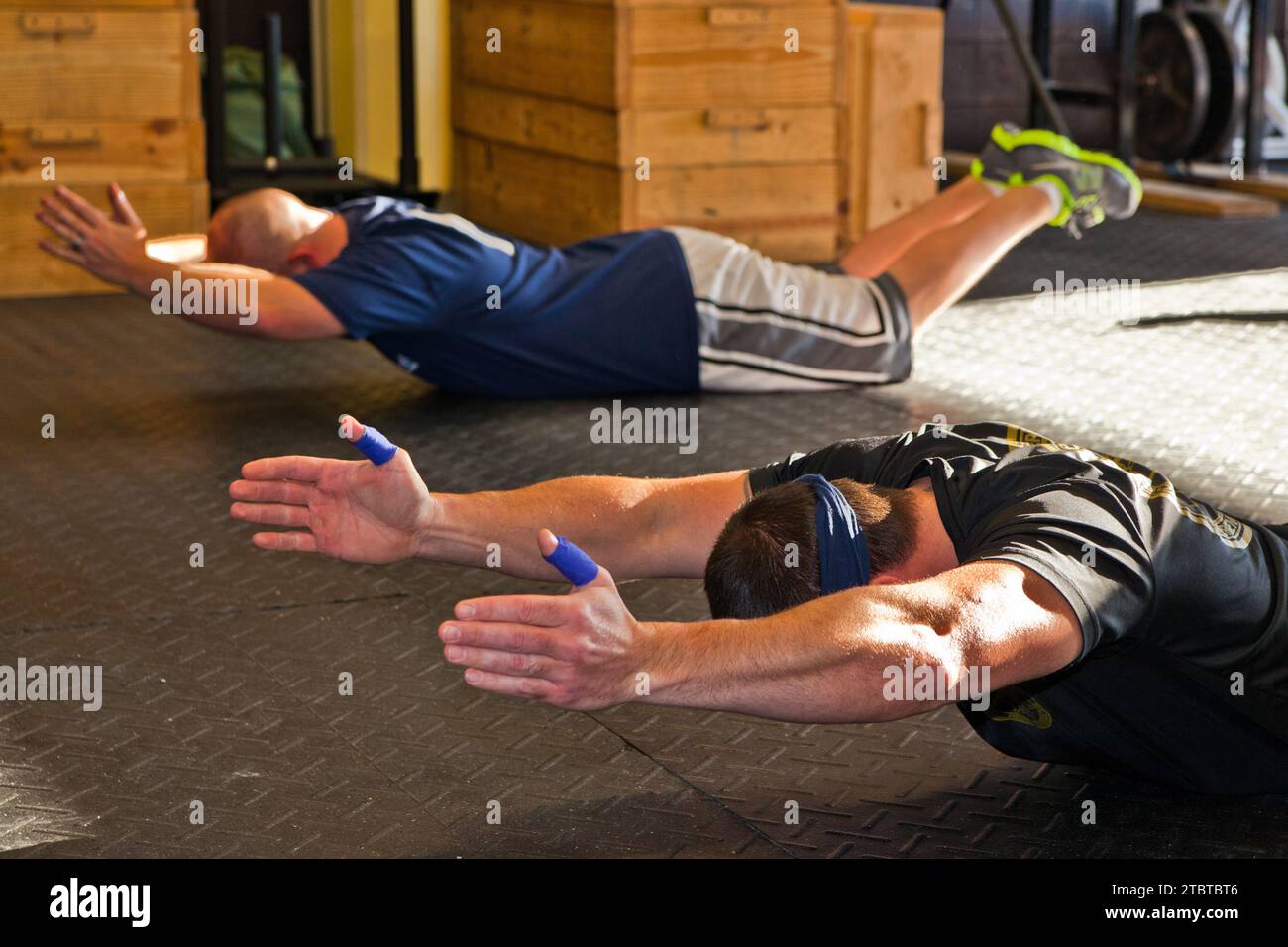 Fitness Partners Performing Superman Exercise in Gym Setting Stock ...
