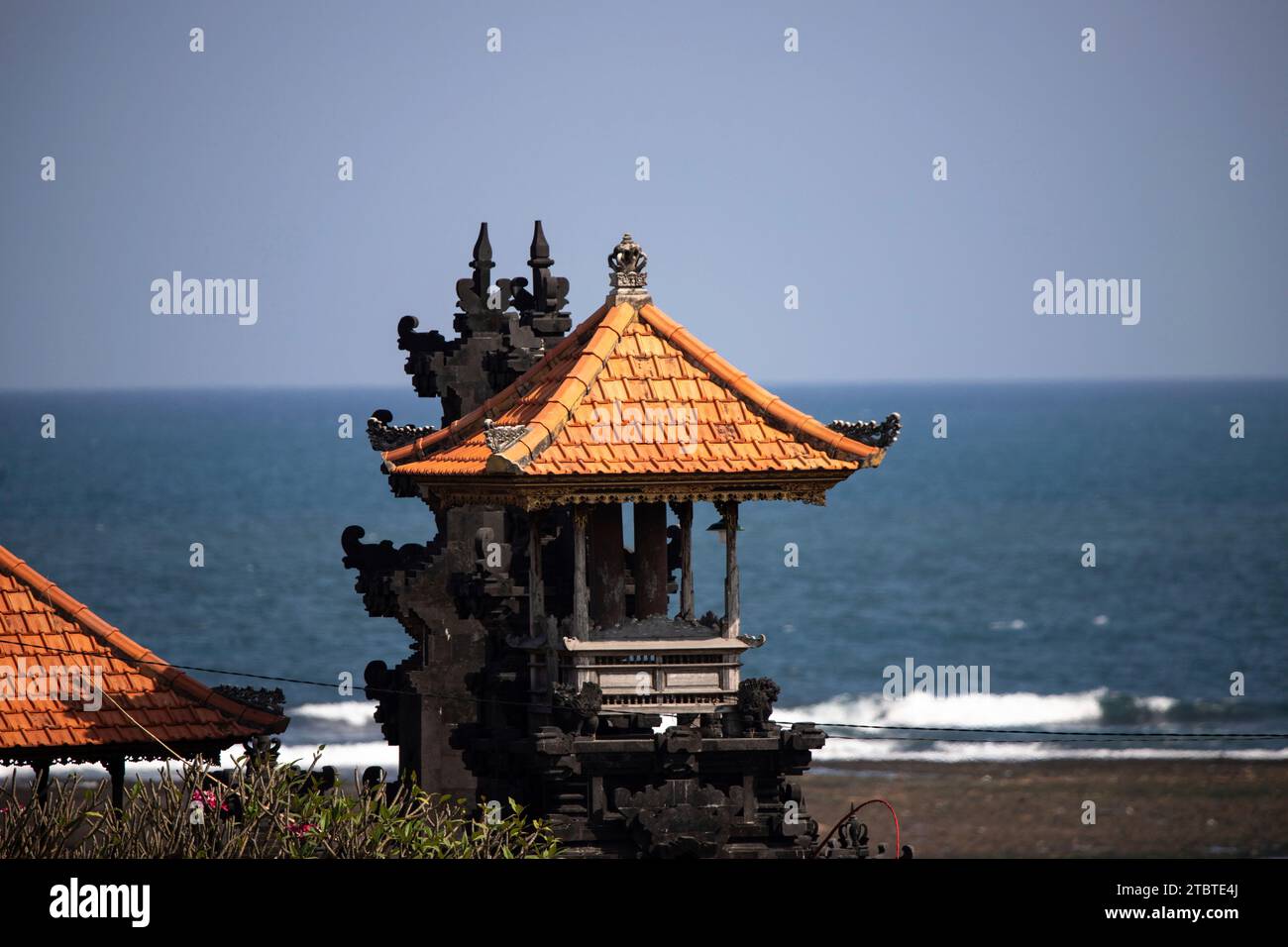 Hindu temple on a black sand beach by the sea, evening landscape with ...