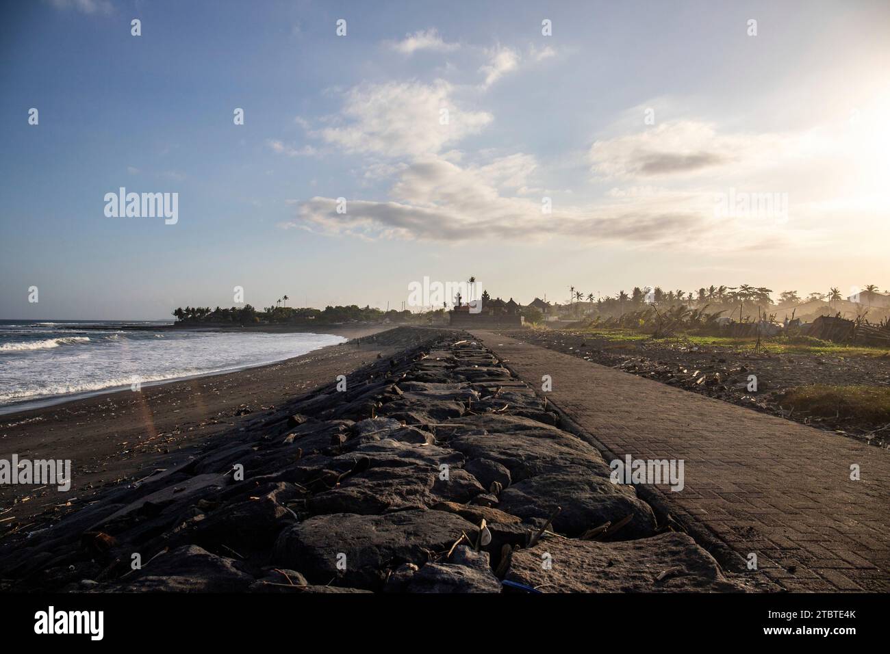 Hindu temple on a black sand beach by the sea, evening landscape with ...