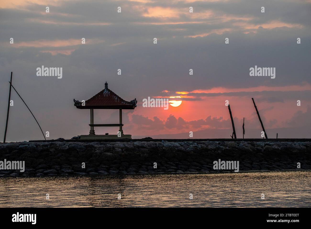 Sunrise on sandy beach with small temples in the water, landscape shot ...