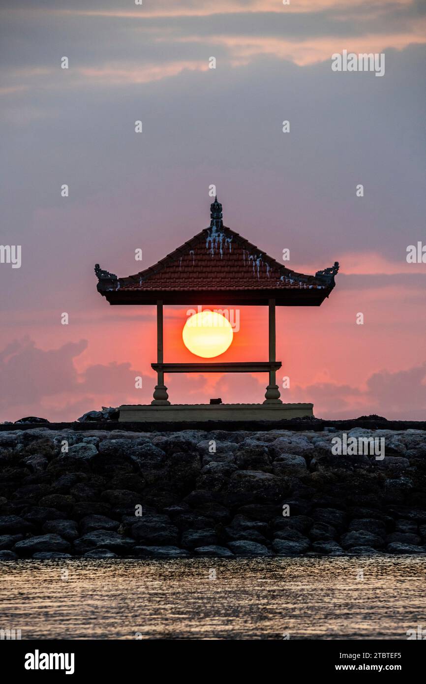 Sunrise on sandy beach with small temples in the water, landscape shot ...