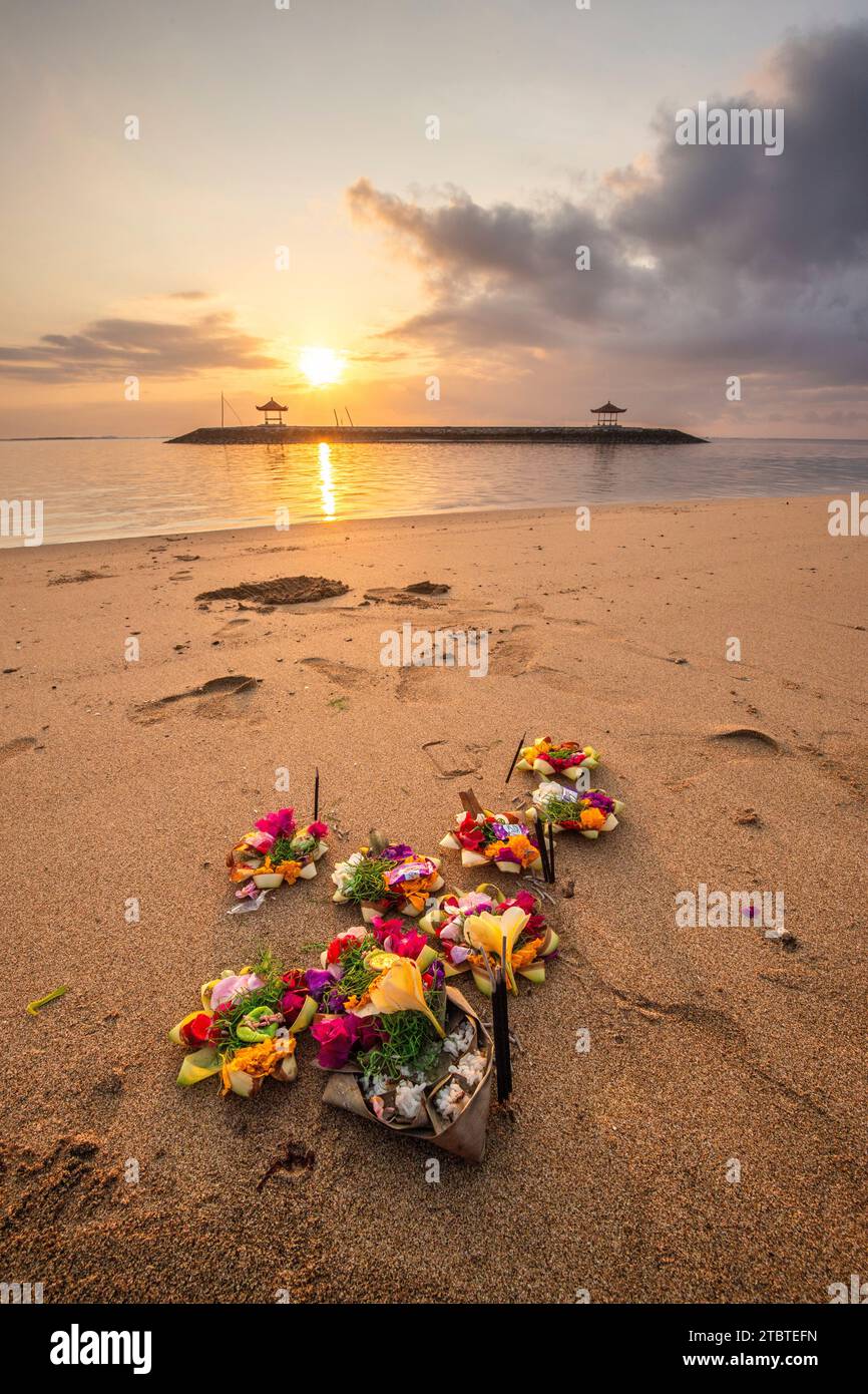 Sunrise on a sandy beach with small temples in the water, landscape ...