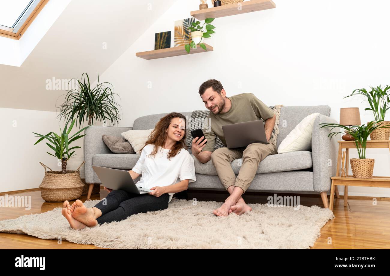 Trusting relationship. Young modern couple use their digital portable ...