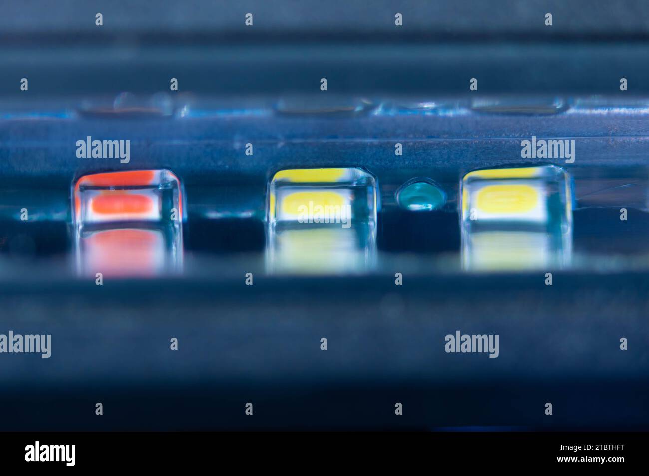 A close-up of three brightly colored magnets placed together in a desk ...