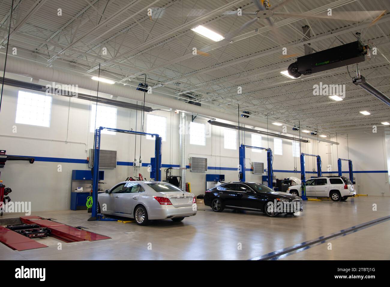 Spacious Automotive Service Center with Three Vehicles in Stages of ...