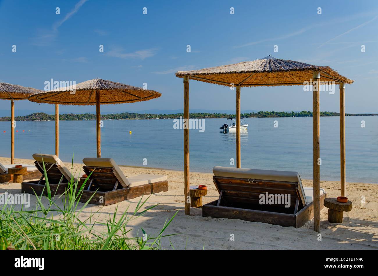 Clean beach with beds under straw umbrellas Stock Photo - Alamy