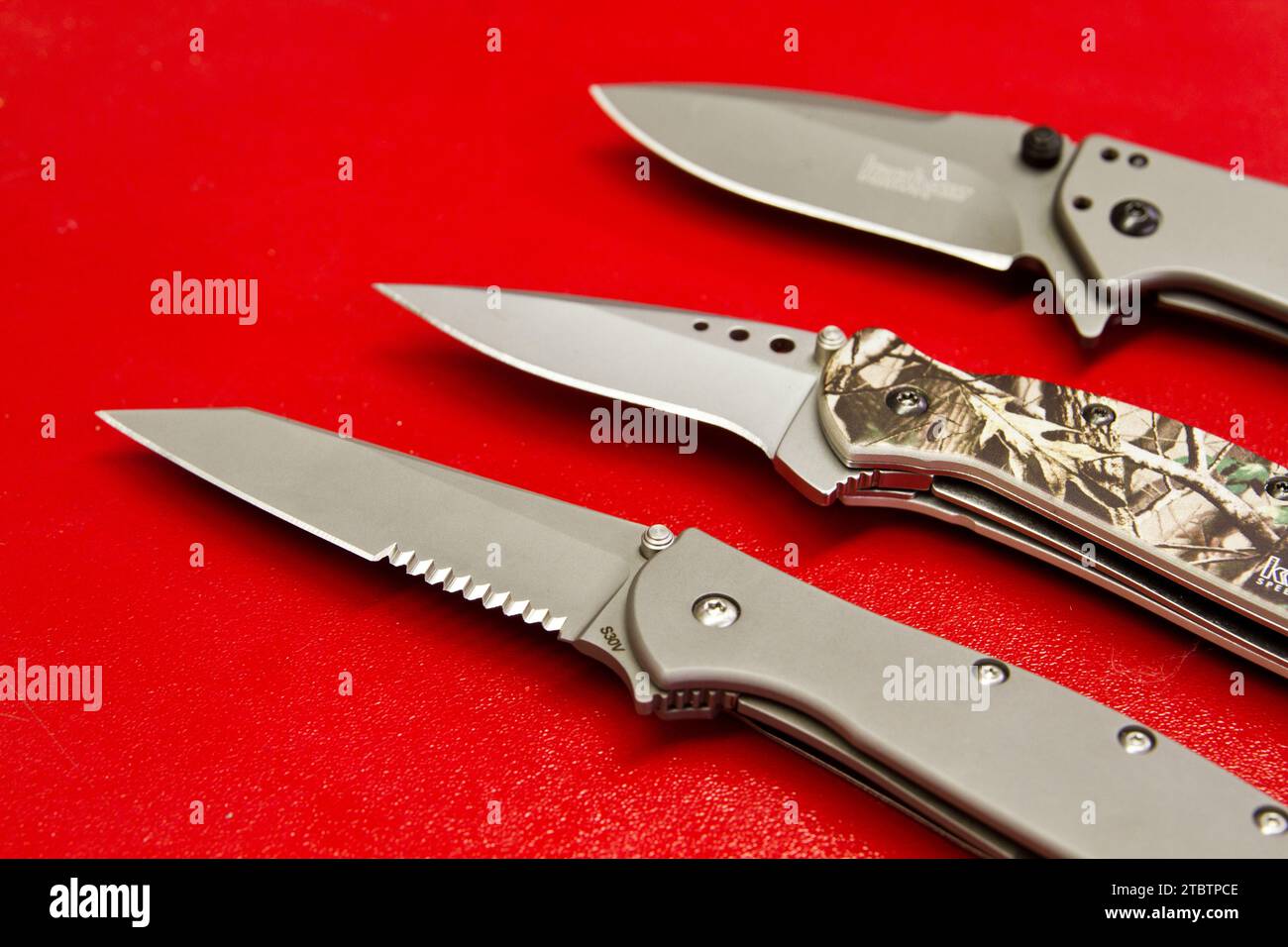 Variety of Folding Knives on Vibrant Red Background in Staggered ...
