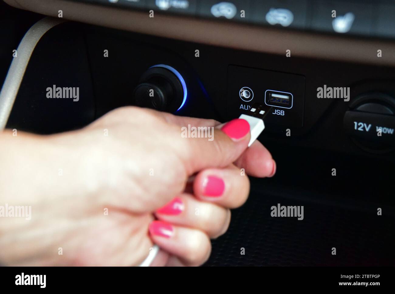 Hand plugging USB cable into the USB port on the car dashboard Stock ...