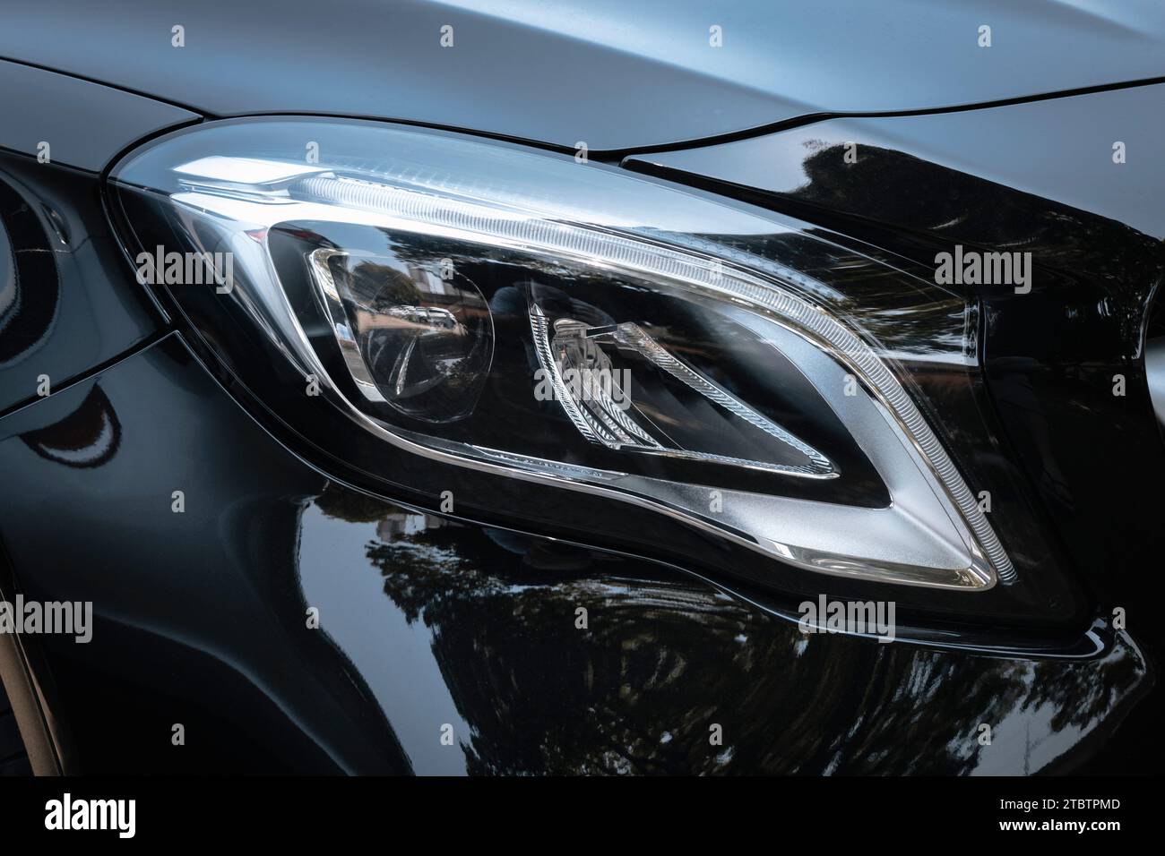 A close up image of a modern frontal car's headlight. Modern lines ...