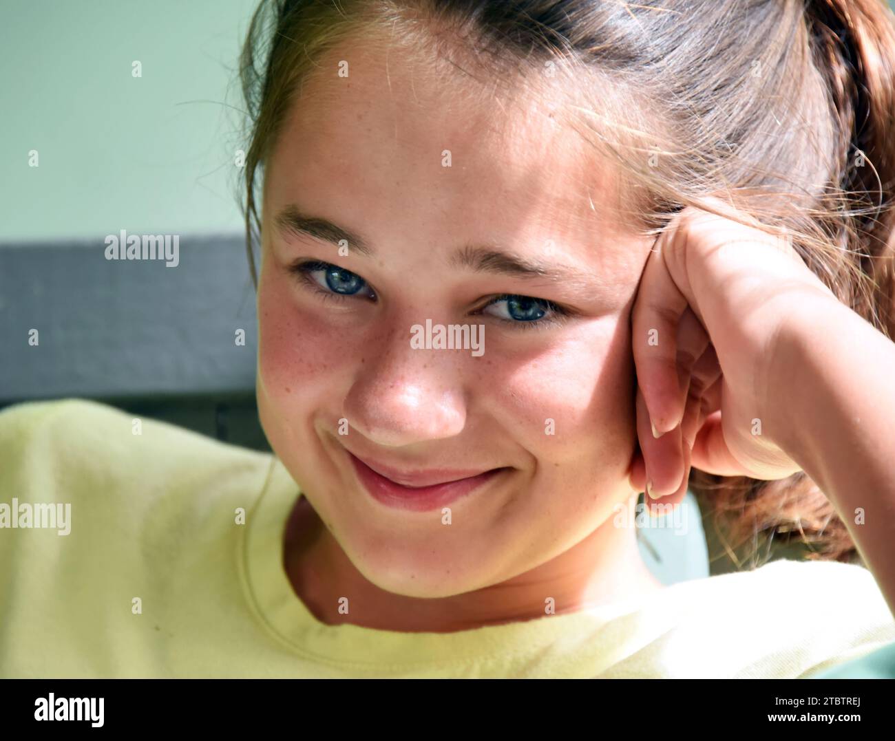 Young girl looks up with a smile on her face. She is happy and it oozes ...