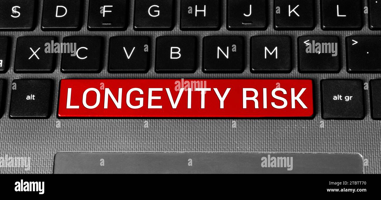 LONGEVITY RISK text written on gray background with pen and calculator ...