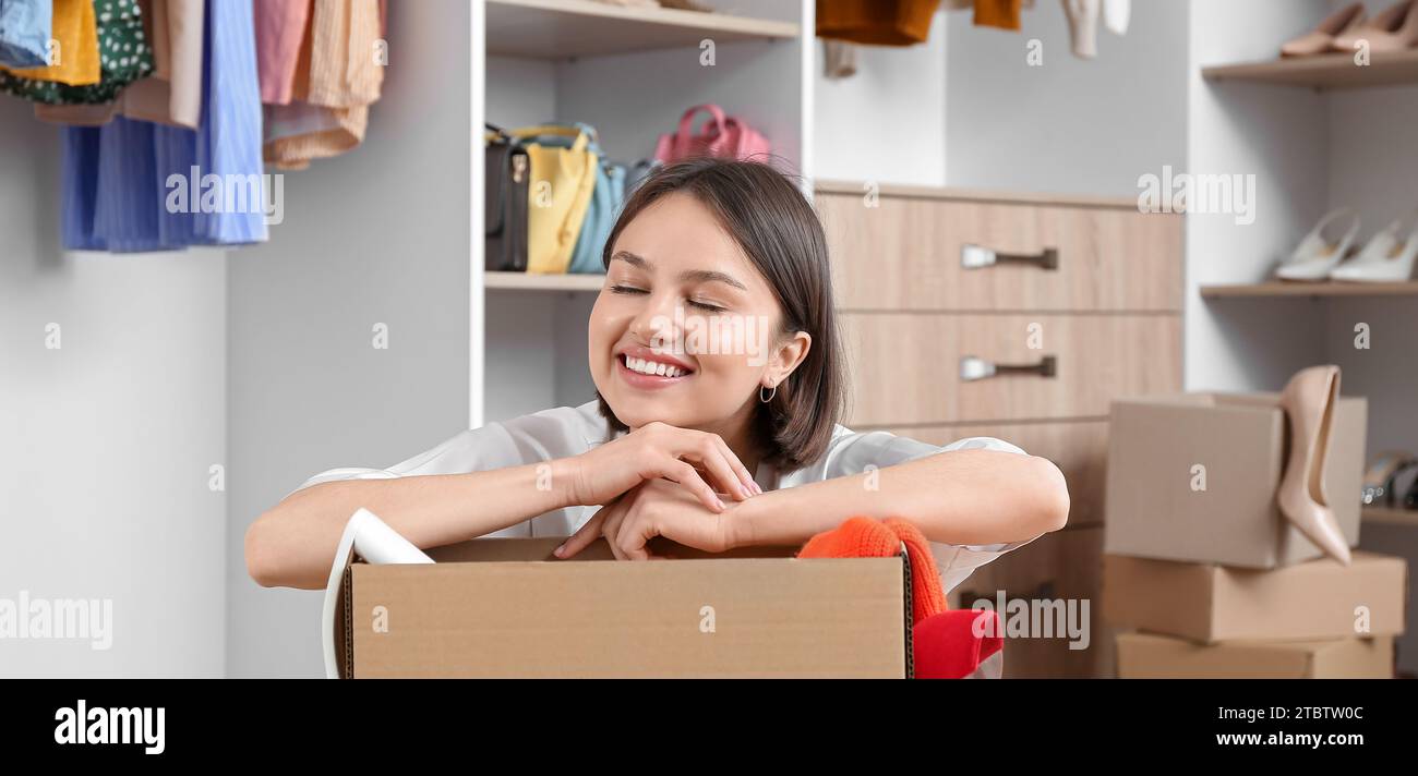 Happy woman with wardrobe box and clothes in dressing room Stock Photo ...