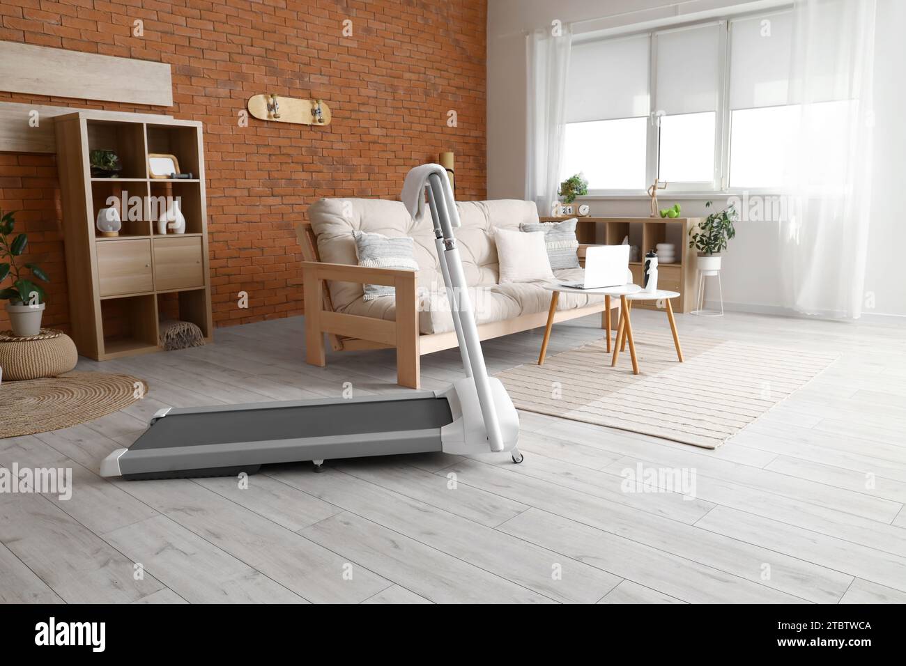 Interior of living room with sofa and treadmill Stock Photo - Alamy