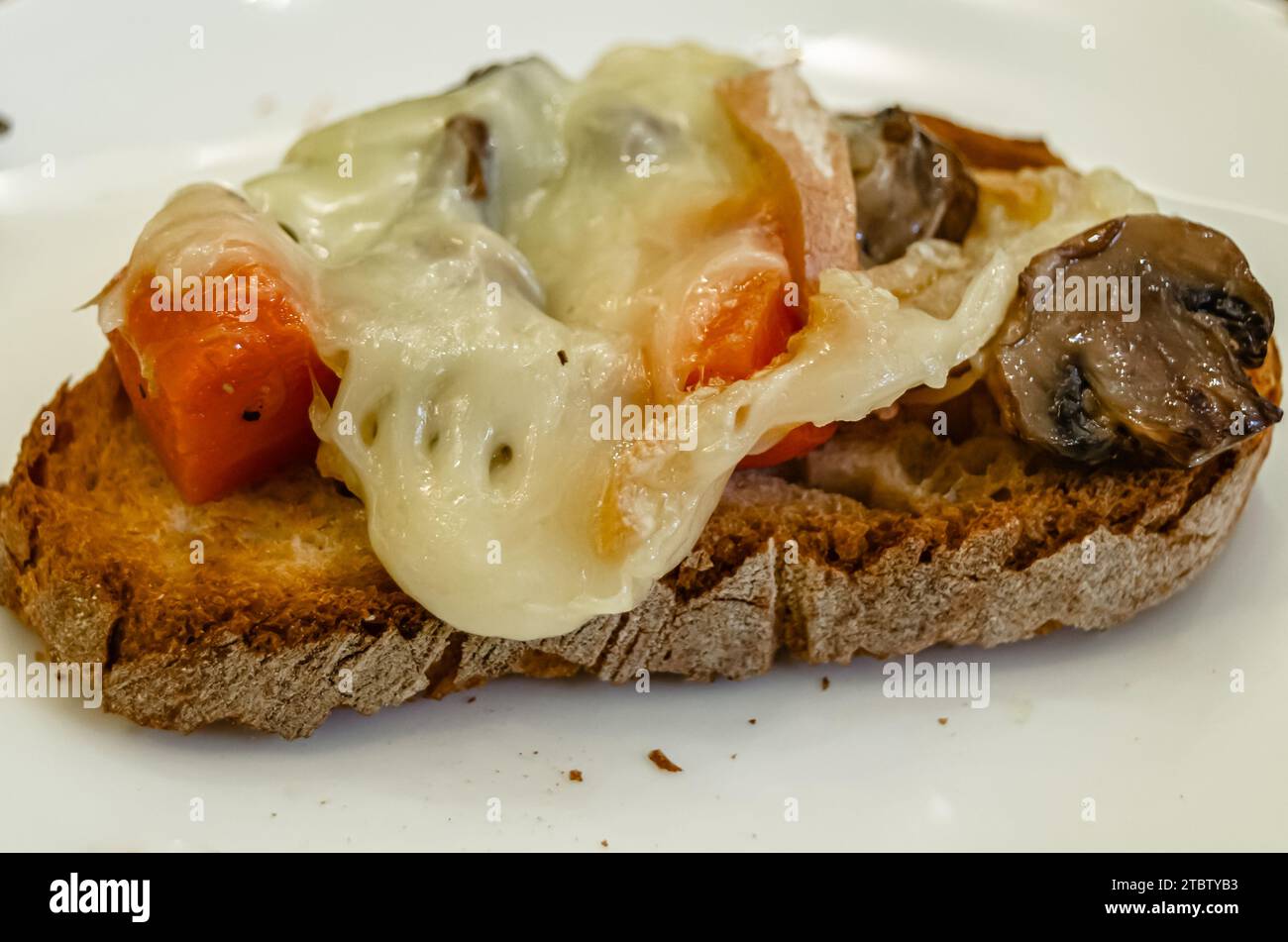 Presentation of a raclette, typical Swiss food, melted cheese on toast ...