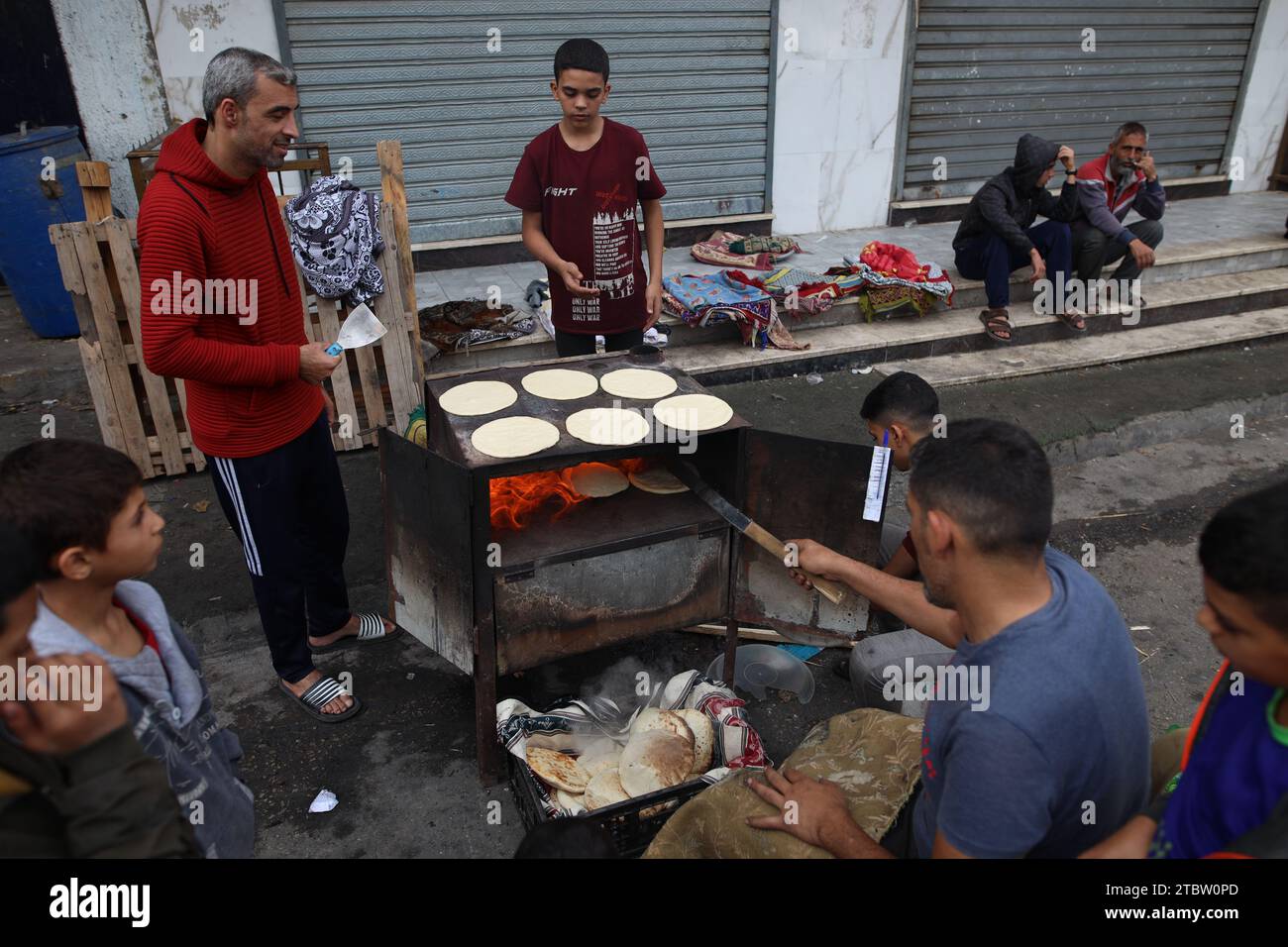 Maghazi Refugee Camp. 8th Dec, 2023. People prepare food at a street ...