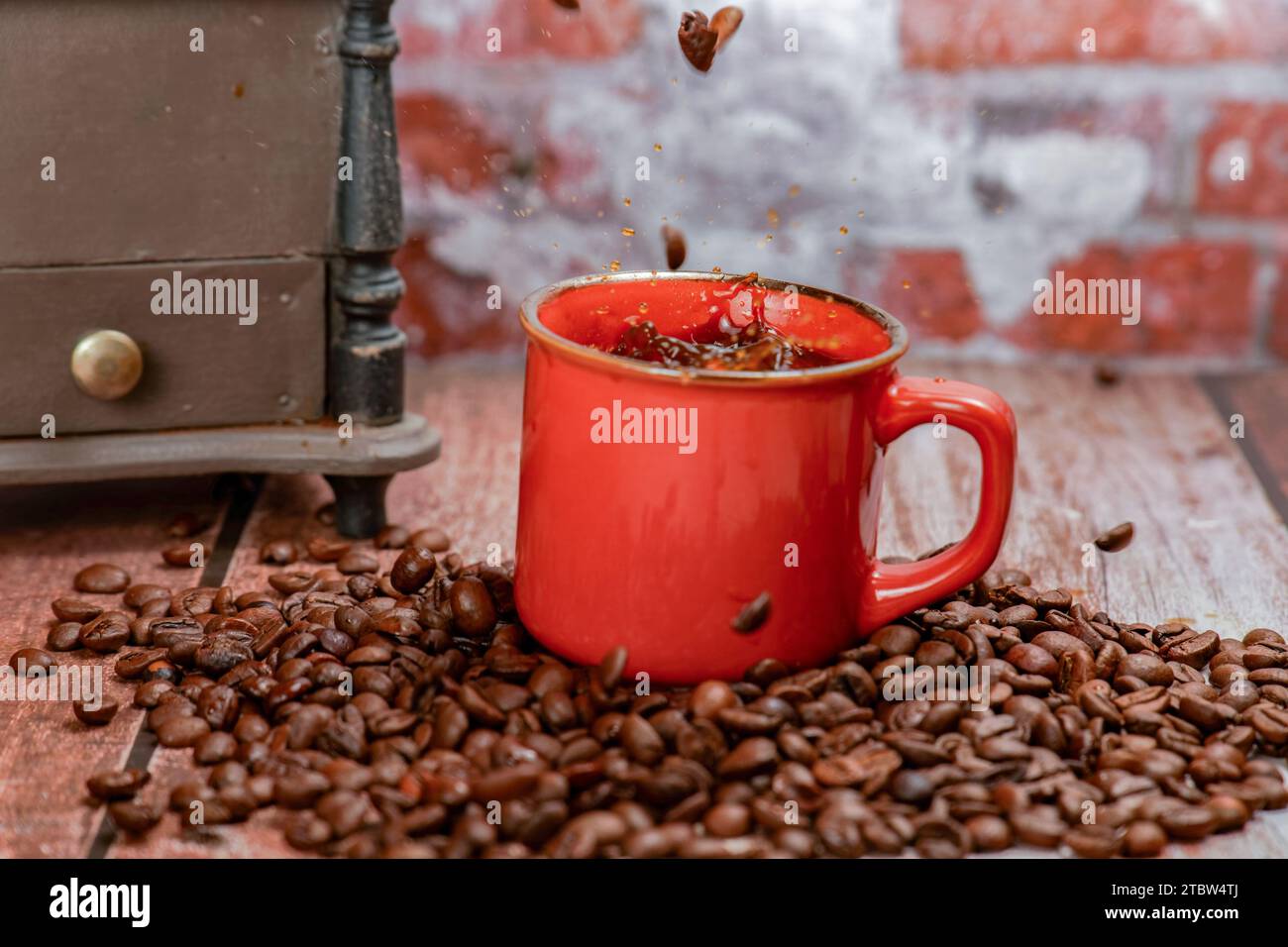 red coffee mug with coffee beans falling inside with splash effect ...