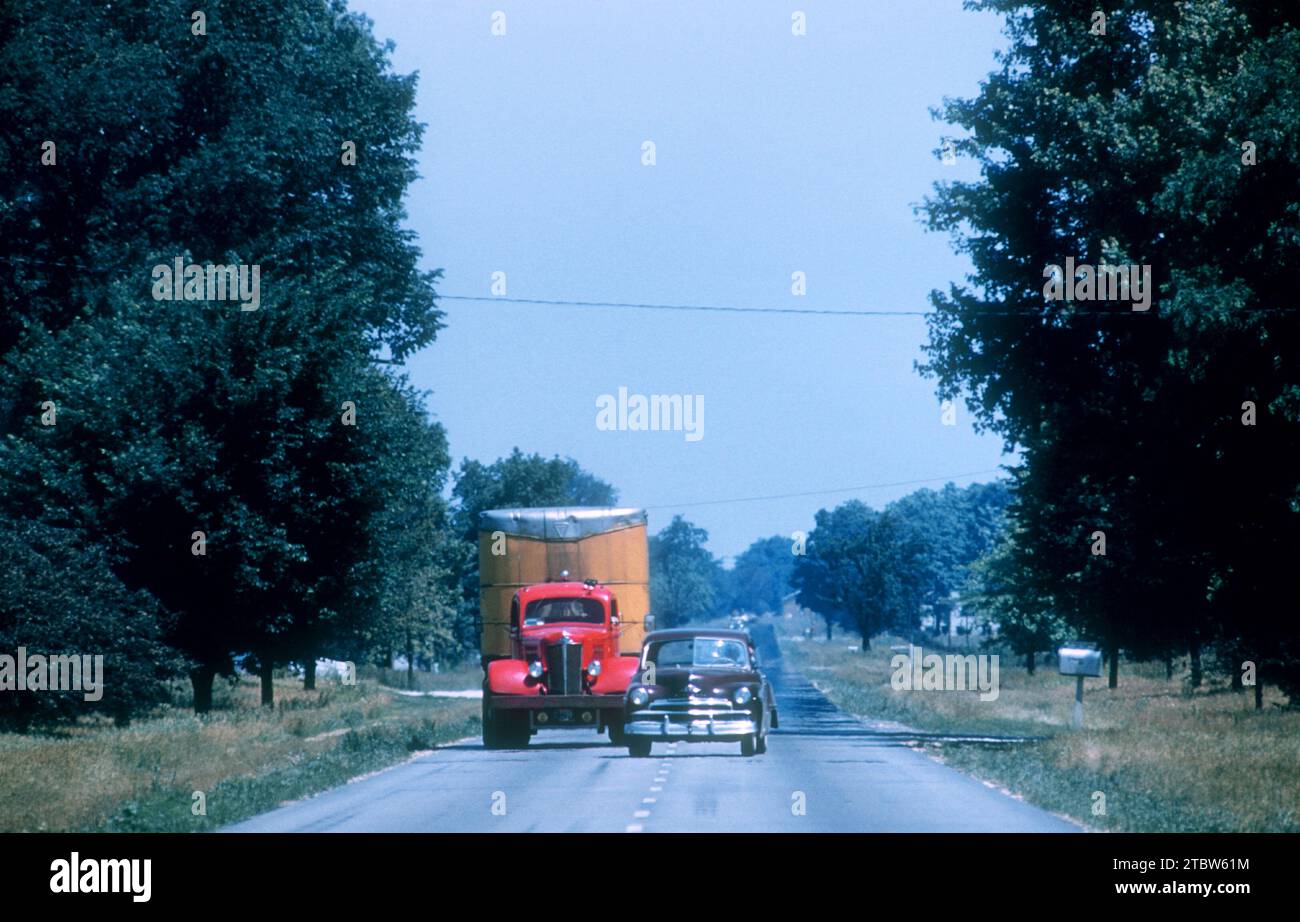 1950'S: An early 1950's Chevrolet passes a truck on an American highway ...