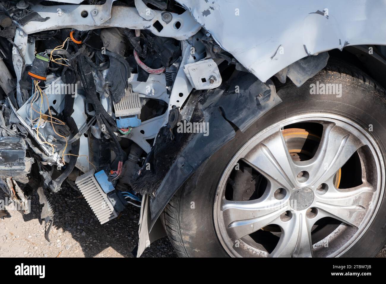 car after an accident, severed wires dangle from the front of damaged ...
