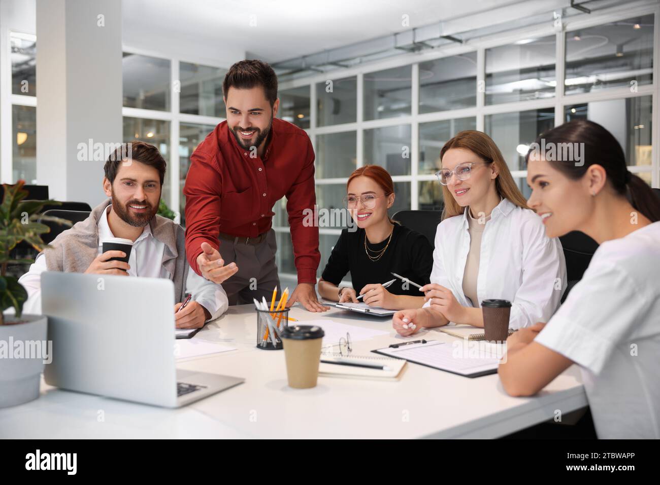 Team of employees working together in office Stock Photo - Alamy