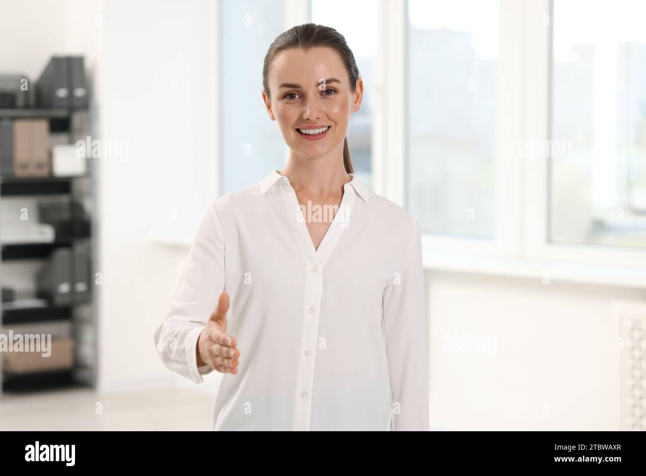 Happy woman welcoming and offering handshake in office Stock Photo - Alamy