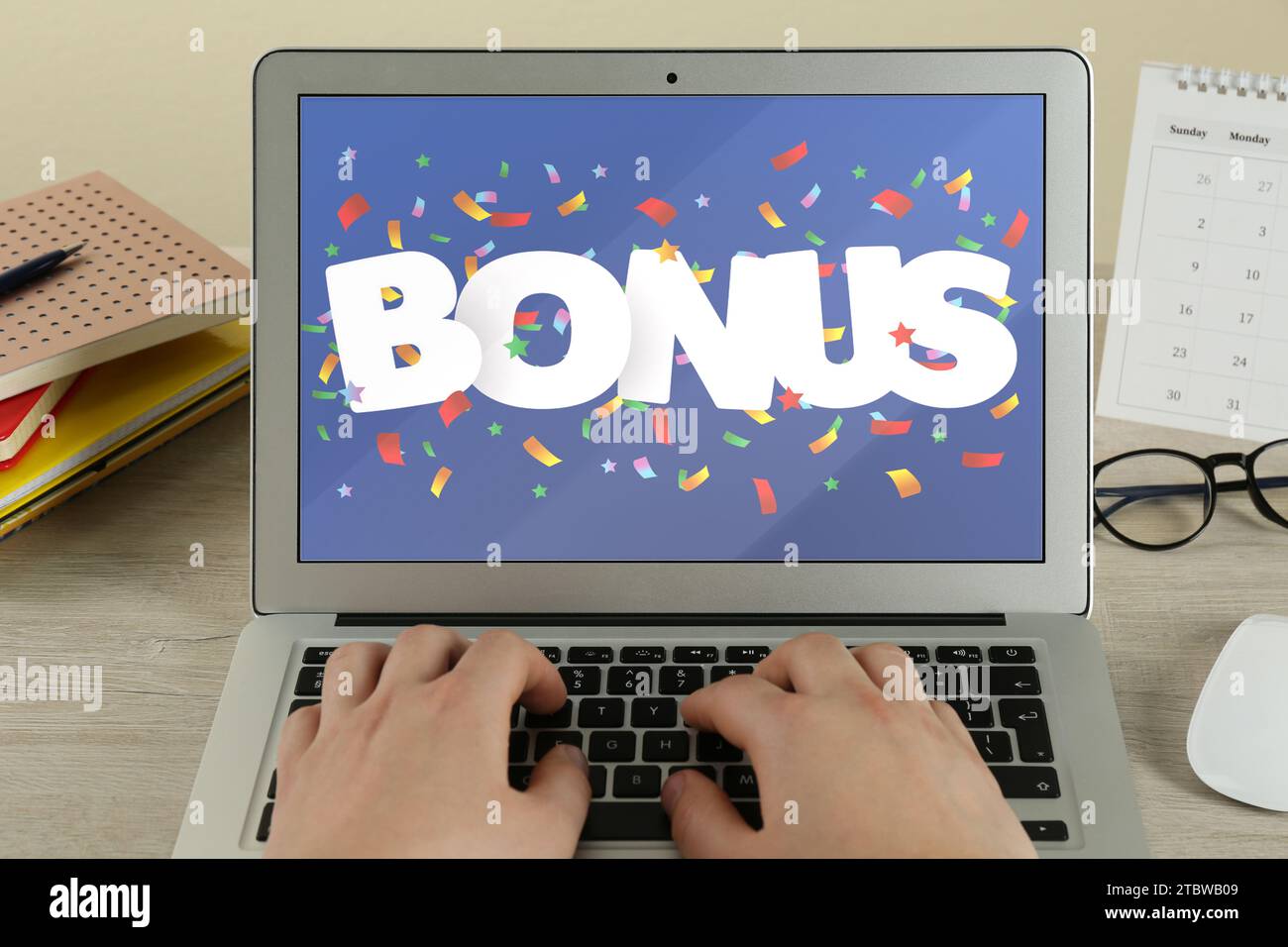 Bonus gaining. Woman using laptop at wooden table, closeup ...