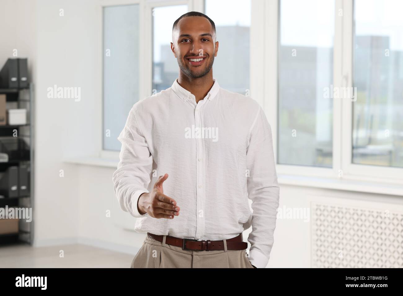 Happy man welcoming and offering handshake in office Stock Photo - Alamy