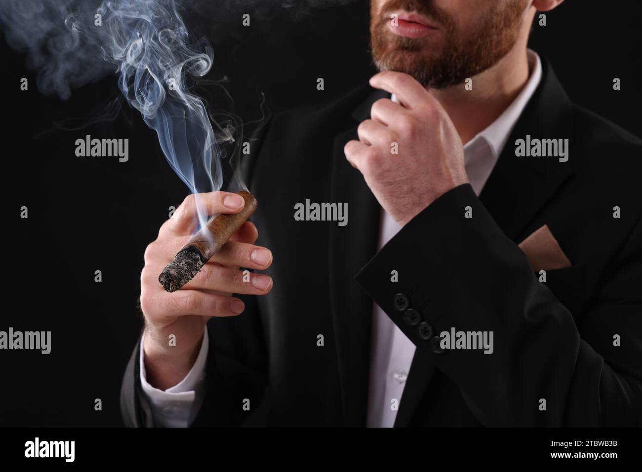 Man in elegant suit smoking cigar on black background, closeup Stock Photo - Alamy