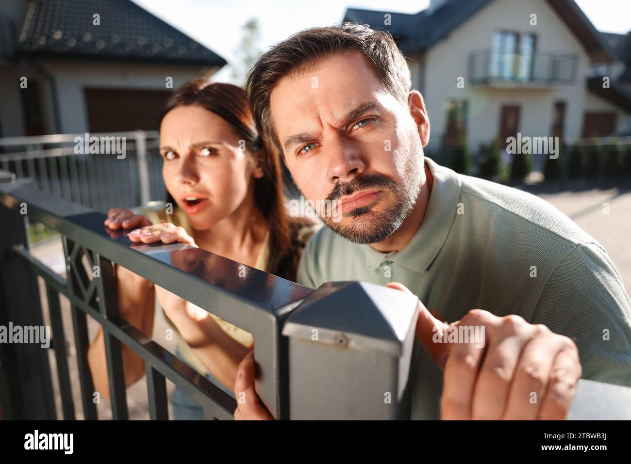 Concept of private life. Curious couple spying on neighbours over fence ...