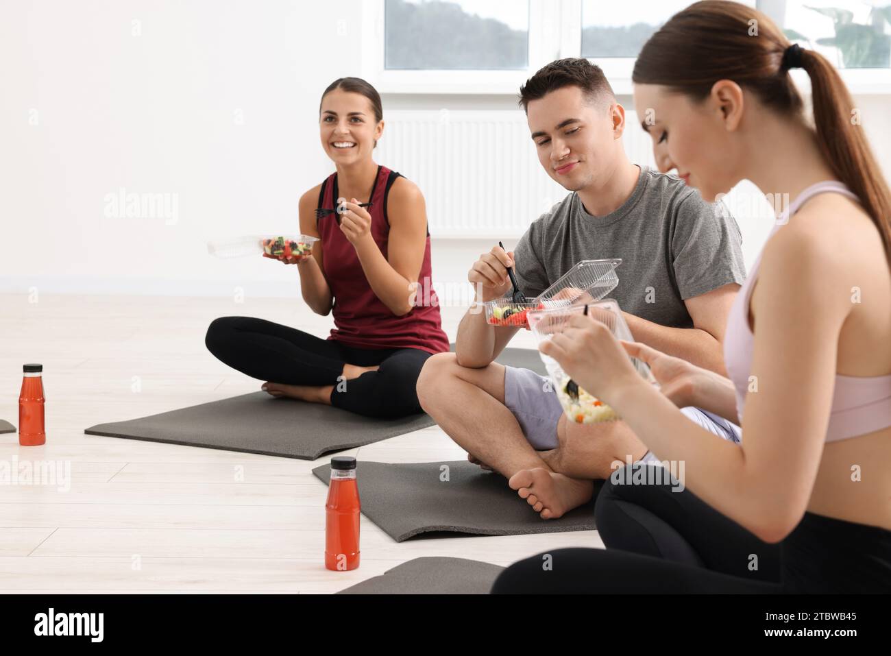 Group of people eating healthy food after yoga class indoors Stock ...