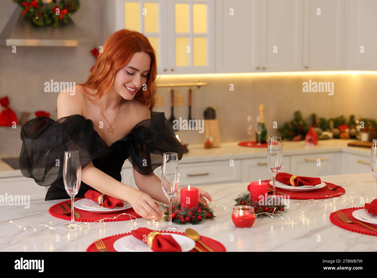 Beautiful young woman setting table for Christmas celebration in ...