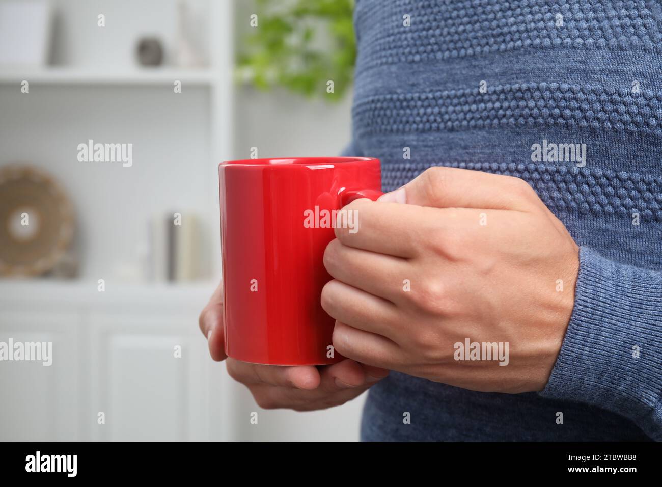 Man holding red mug at home, closeup. Mockup for design Stock Photo - Alamy