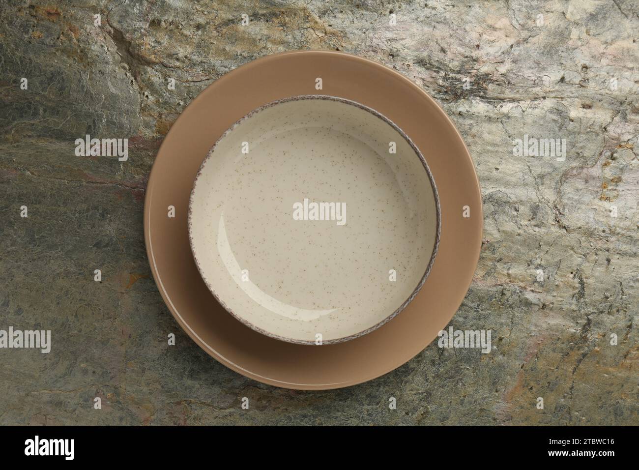Beautiful beige ceramic plates on gray textured table, top view Stock ...