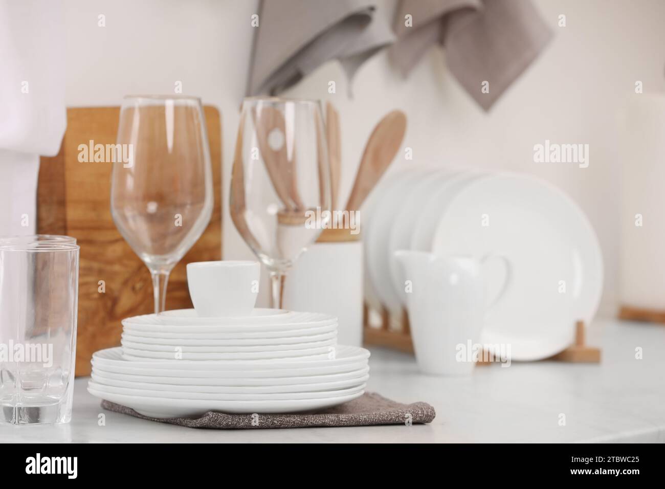 Clean dishes on light table in kitchen Stock Photo - Alamy