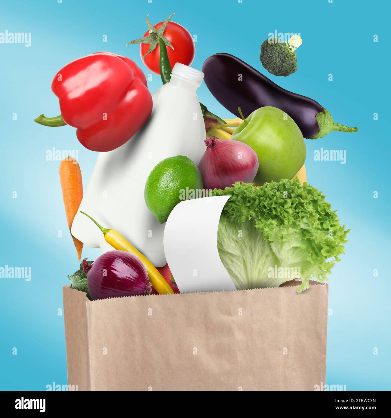 Different food products falling into paper bag on light blue background ...