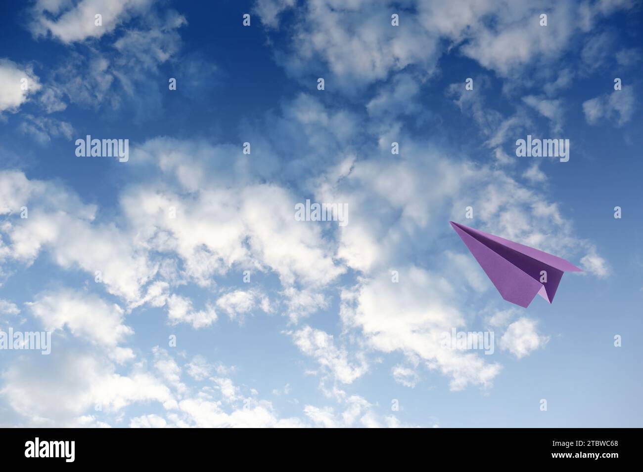 Purple paper plane flying in blue sky with clouds Stock Photo - Alamy
