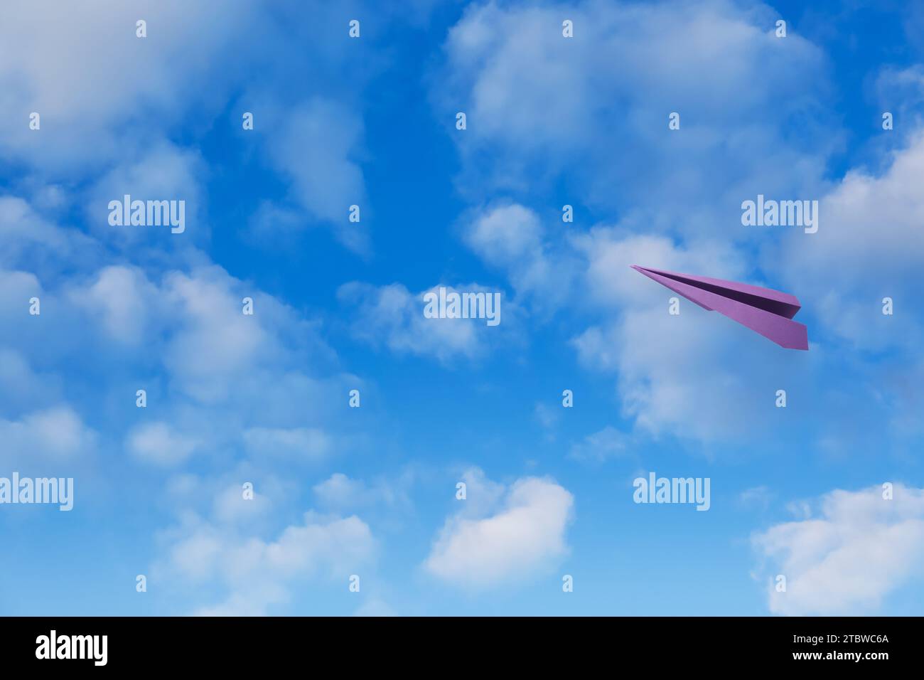 Purple paper plane flying in blue sky with clouds Stock Photo - Alamy
