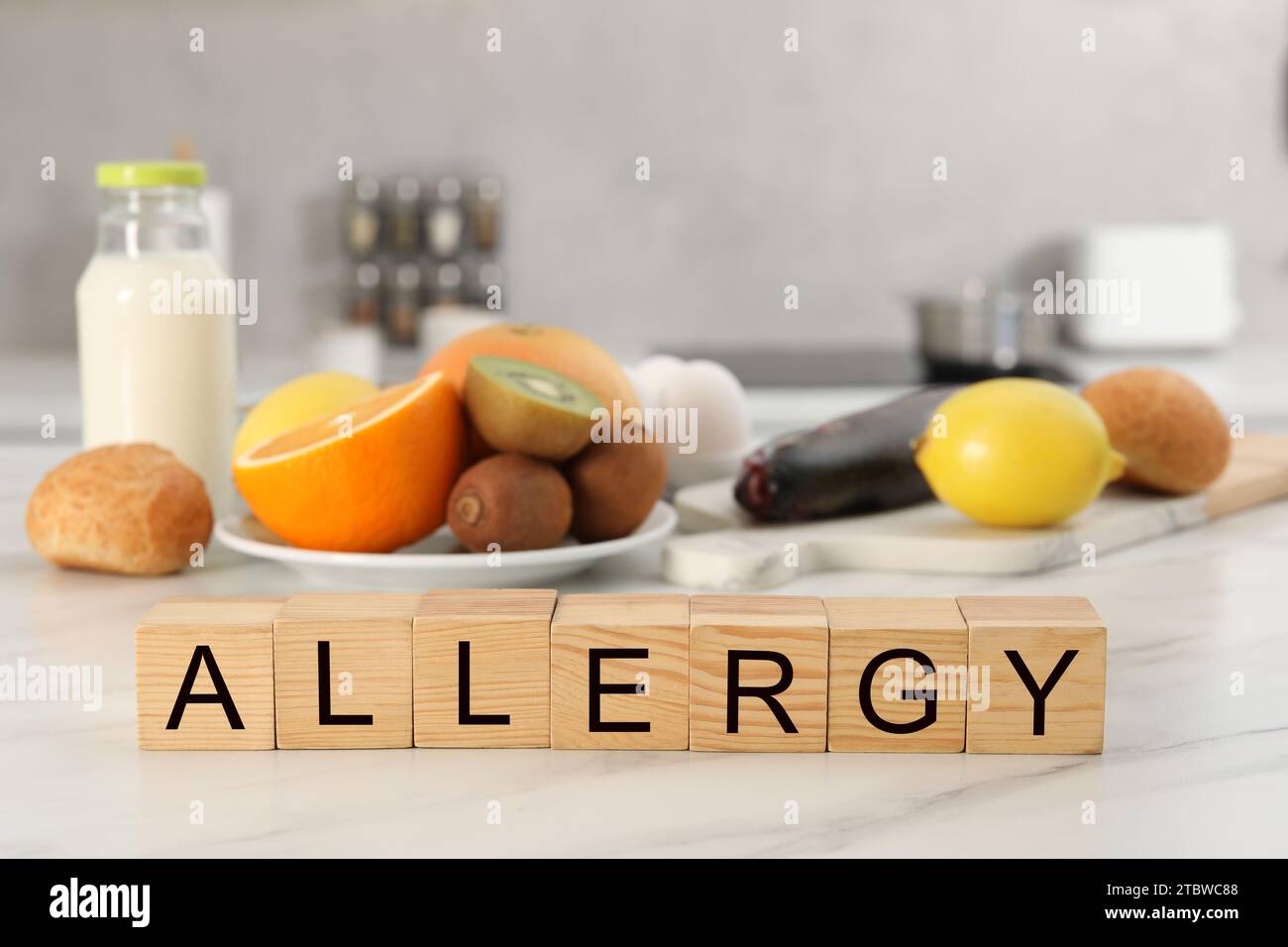 Food allergy. Different fresh products and wooden cubes on white marble ...
