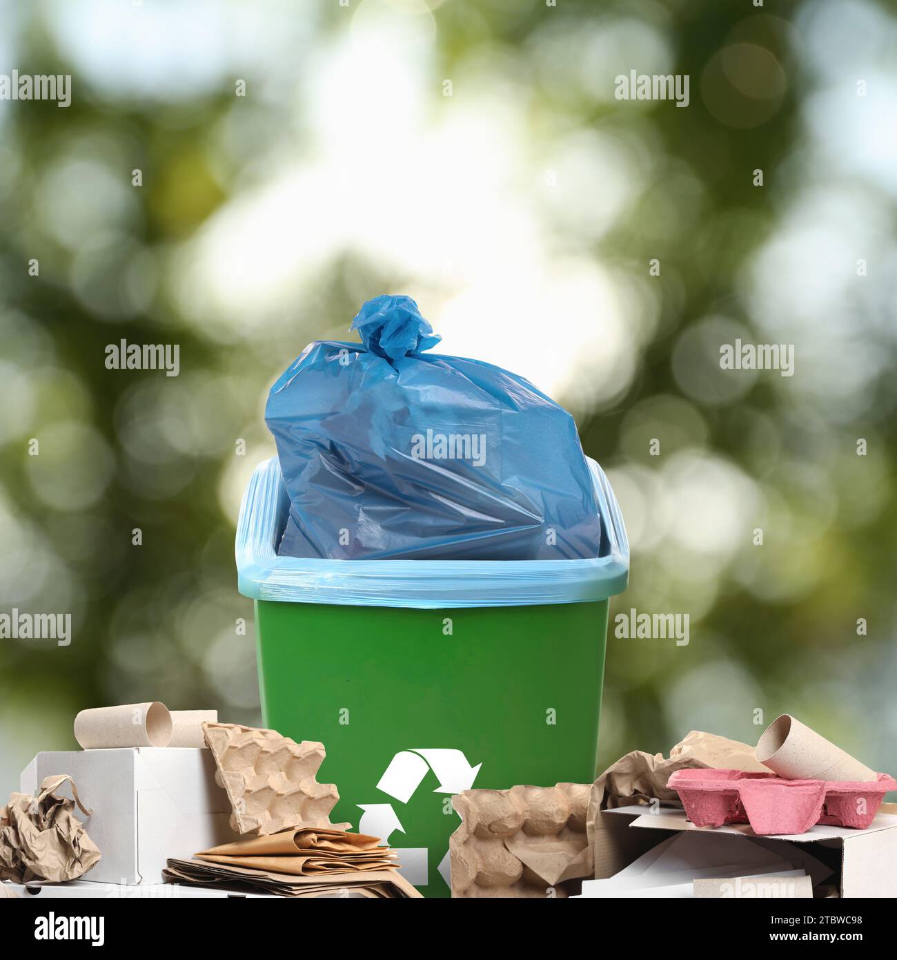 Waste bin with plastic bag full of trash surrounded by garbage on ...