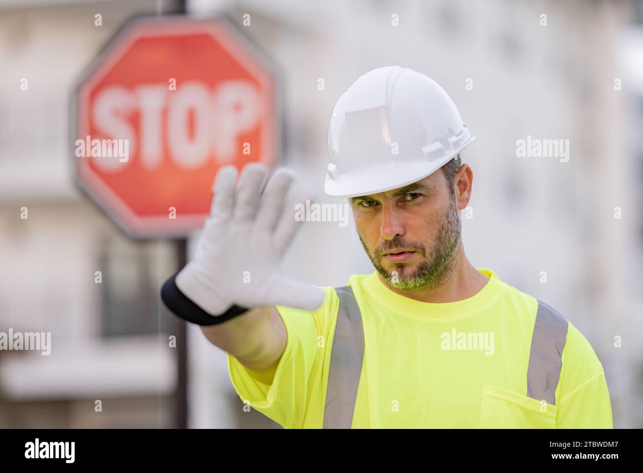 Builder with stop road sign. Builder with stop gesture, no hand ...