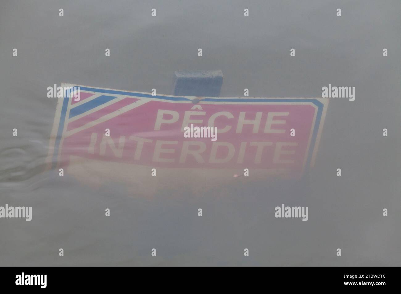 No fishing sign (Pêche interdite) totally submerged during winter ...