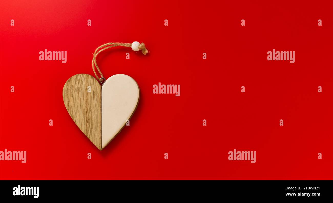 Wooden heart medallion of two separate sides isolated on bright red ...