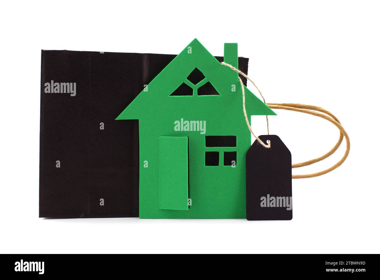 Property concept with cut out paper home and blank label tag near black ...
