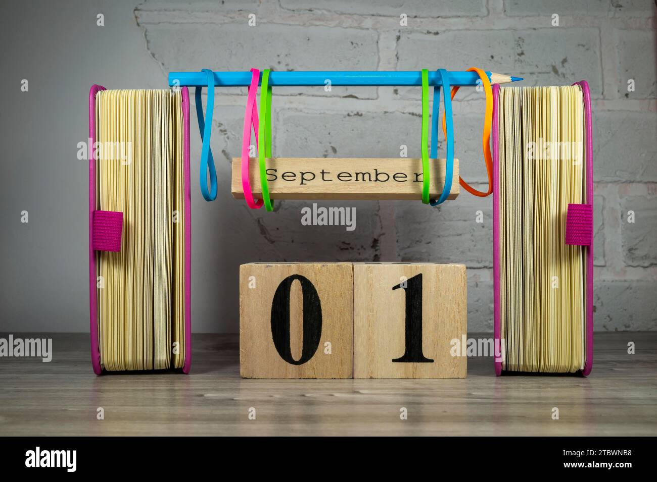 Colorful September still life with books, rubber bands and rustic sign ...