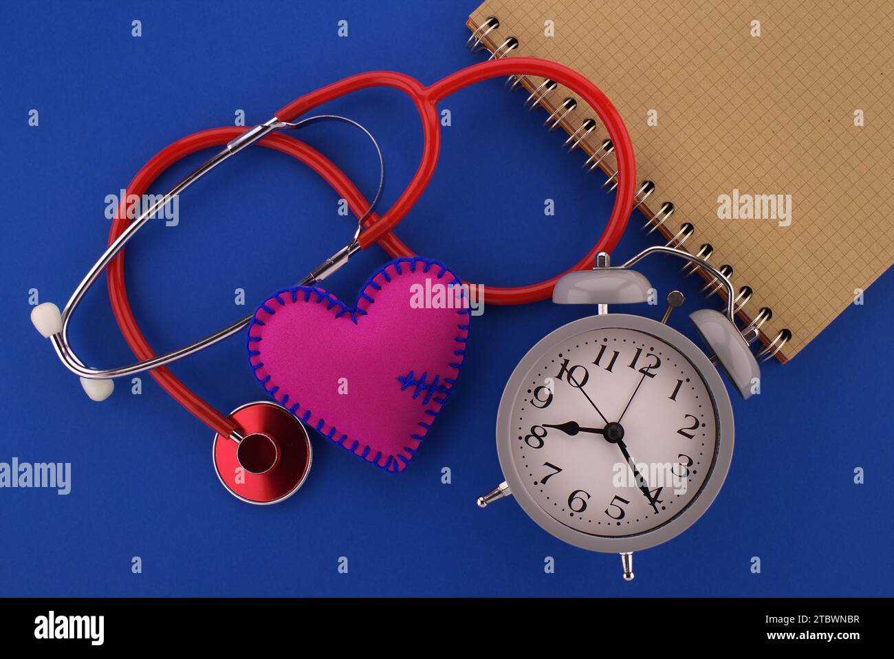 Medical concept with stethoscope and red heart, alarm clock and open ...