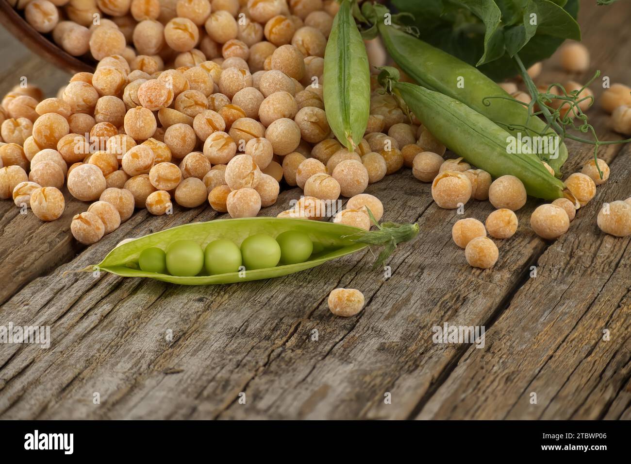 Dry whole yellow peas spilling from a bowl and sweet green peas with ...