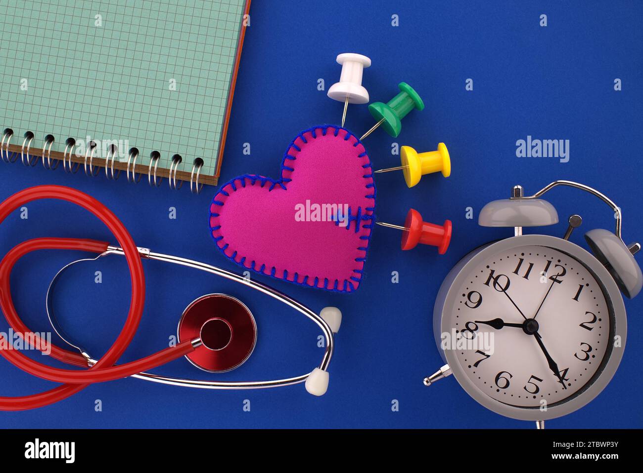 Medical concept with stethoscope and red heart, alarm clock and open ...
