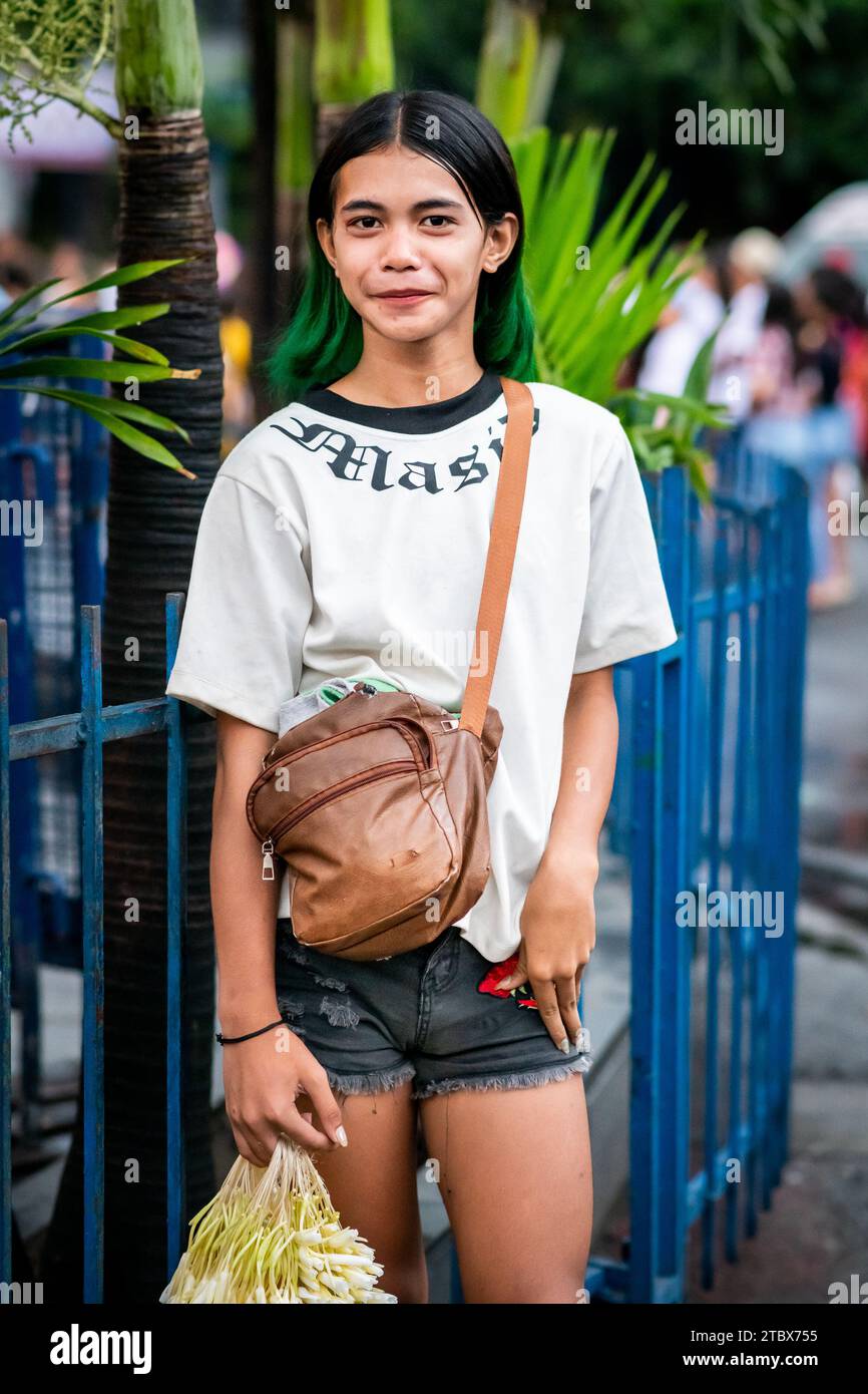 A beautiful young Filipino girl sells flower garlands outside the St ...