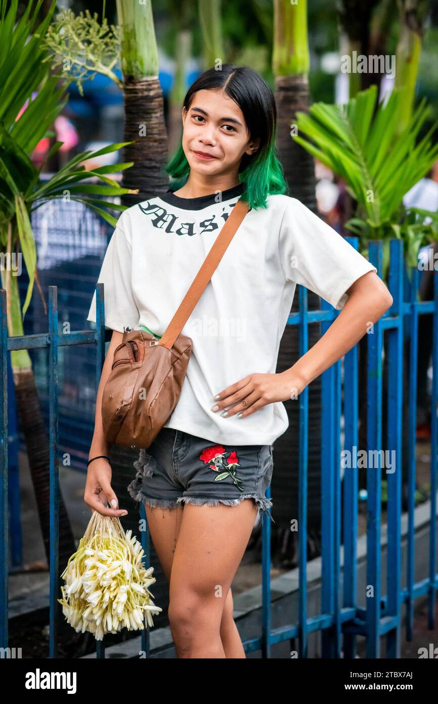 A beautiful young Filipino girl sells flower garlands outside the St ...